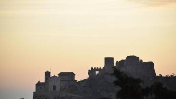 Um edifício histórico com uma torre imponente e uma estrutura fortificada numa colina.