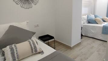 Quarto com cama, mesa de cabeceira e uma obra de arte na parede.