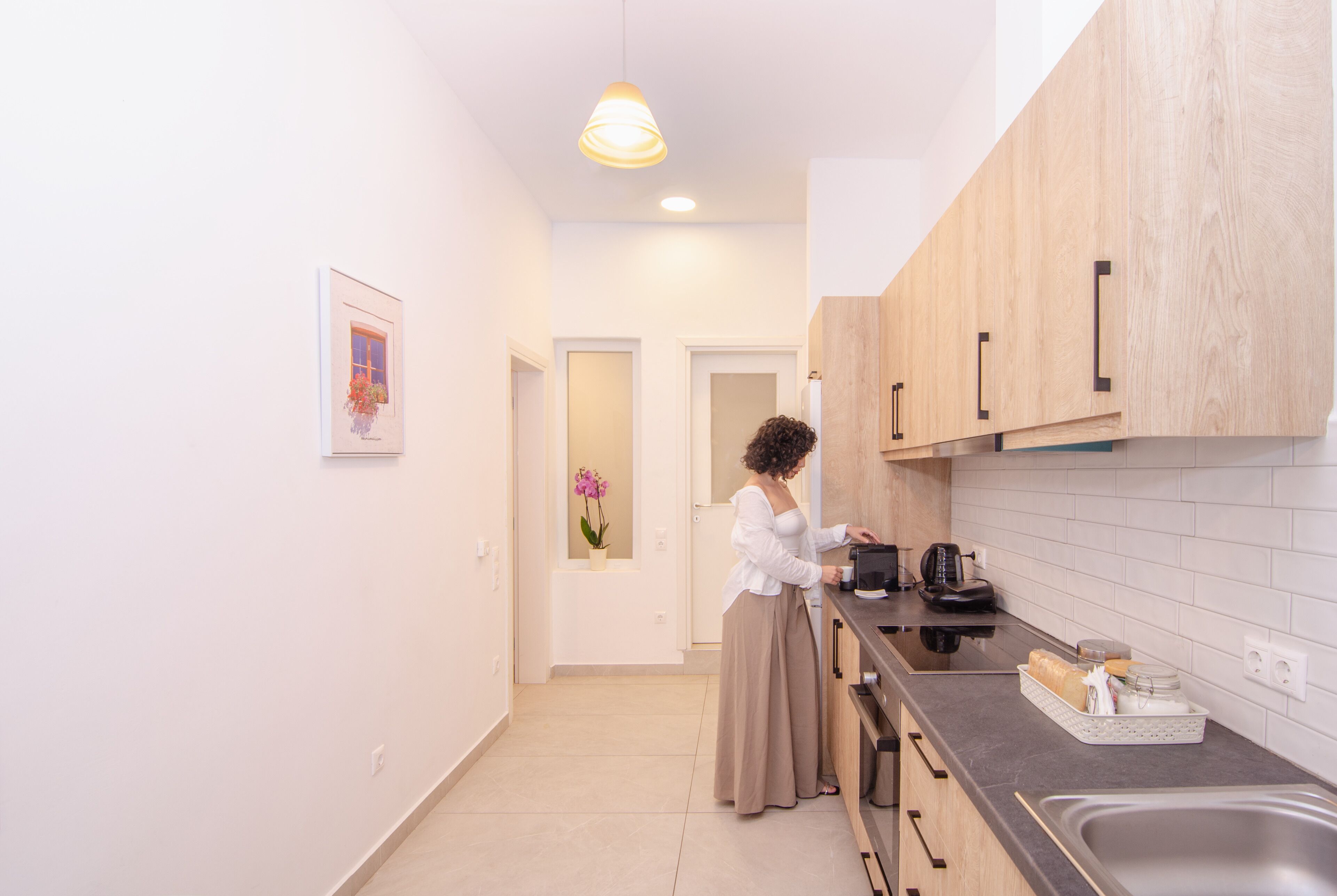 Uma cozinha moderna com armários de madeira, bancada e pia.