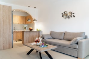 Uma sala de estar moderna com sofá, mesa de centro e um detalhe decorativo na parede.