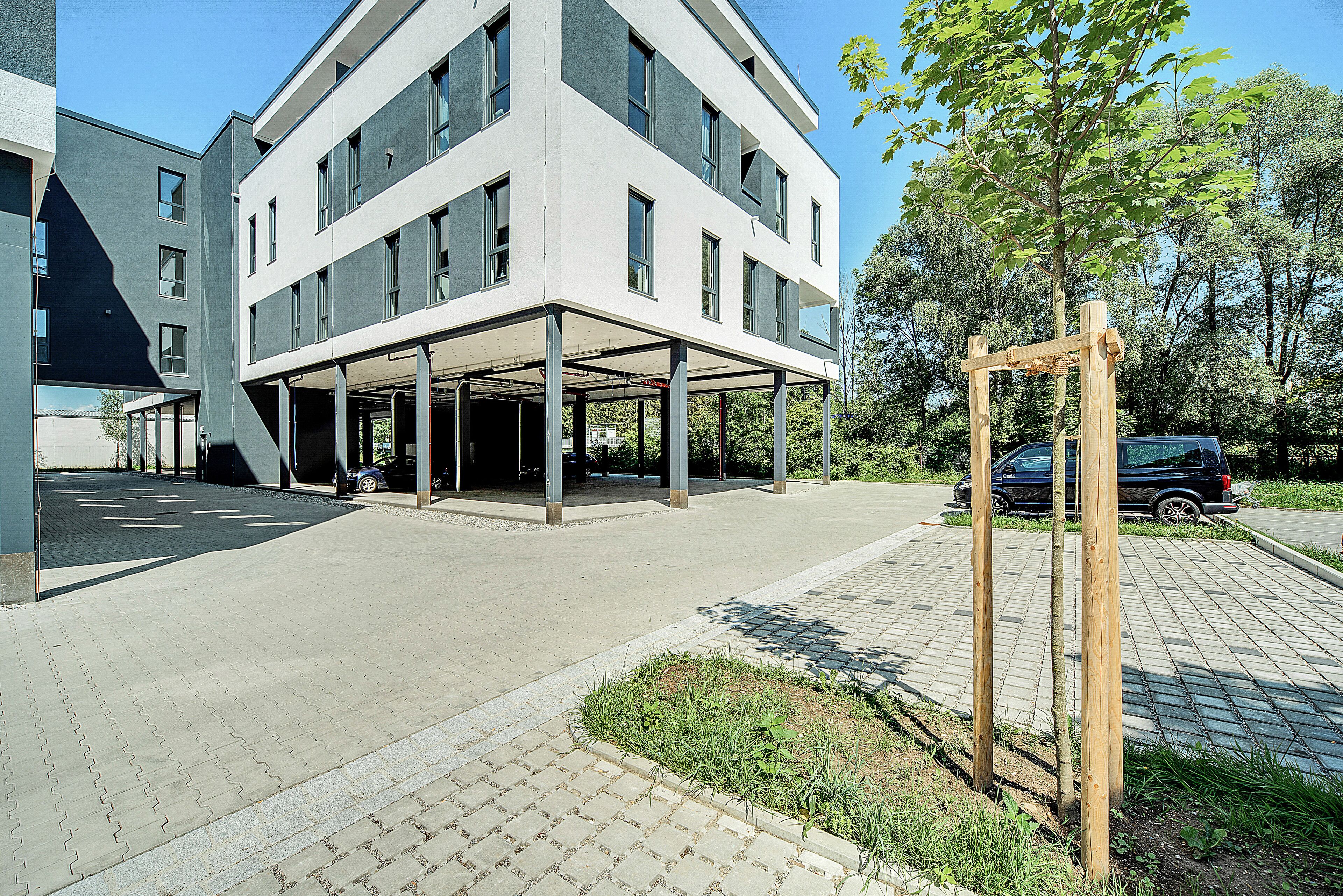 Um edifício moderno com entrada coberta e área de estacionamento.