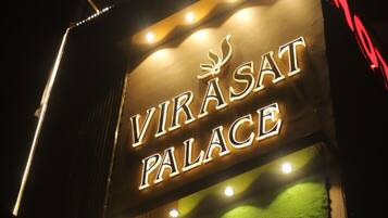 Um edifício com sinalização iluminada que diz "VIRASAT PALACE".