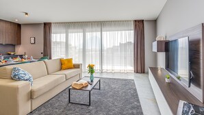 Uma sala de estar moderna com sofá, mesa de centro e televisão.