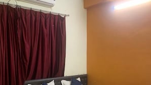 Quarto com uma cama, uma cadeira e uma mesa.