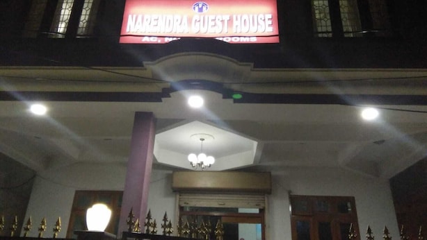 Exterior da Narendra Guest House, com placa visível, portão e fachada bem iluminada.