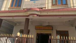 Um edifício de dois andares com uma placa que diz 'Narendra Guest House'.