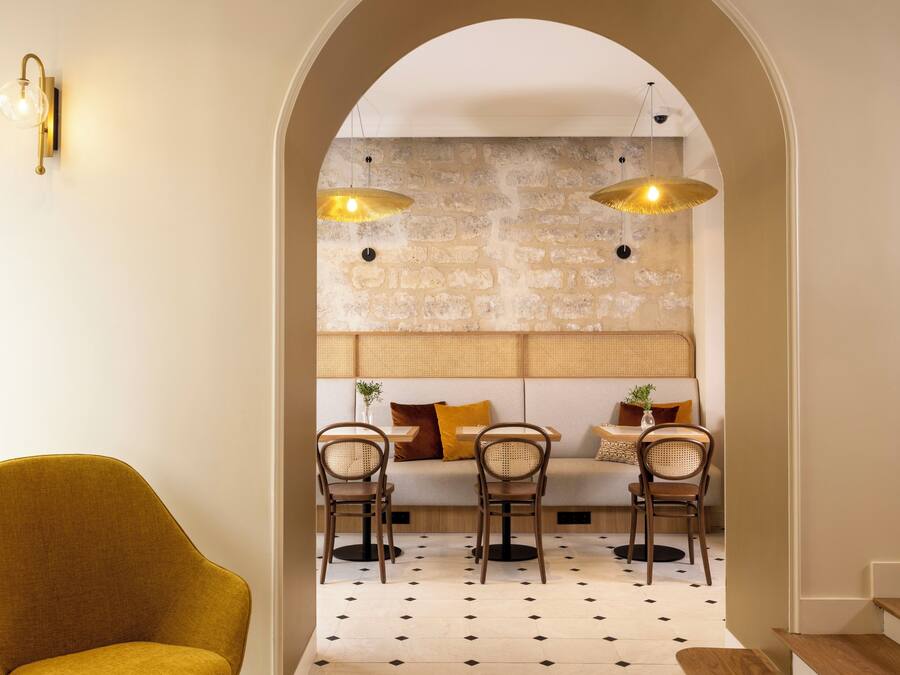 Um interior moderno com um conjunto de sofás, duas cadeiras e uma mesa em um corredor com uma porta em arco.