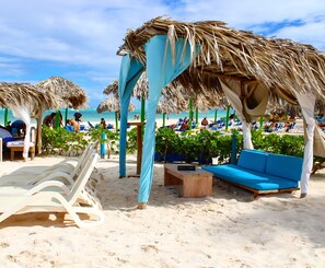 Praia particular, areia branca, espreguiçadeiras, guarda-sóis 