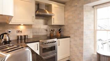 Um frigorífico, uma máquina de lavar louça, utensílios de cozinha