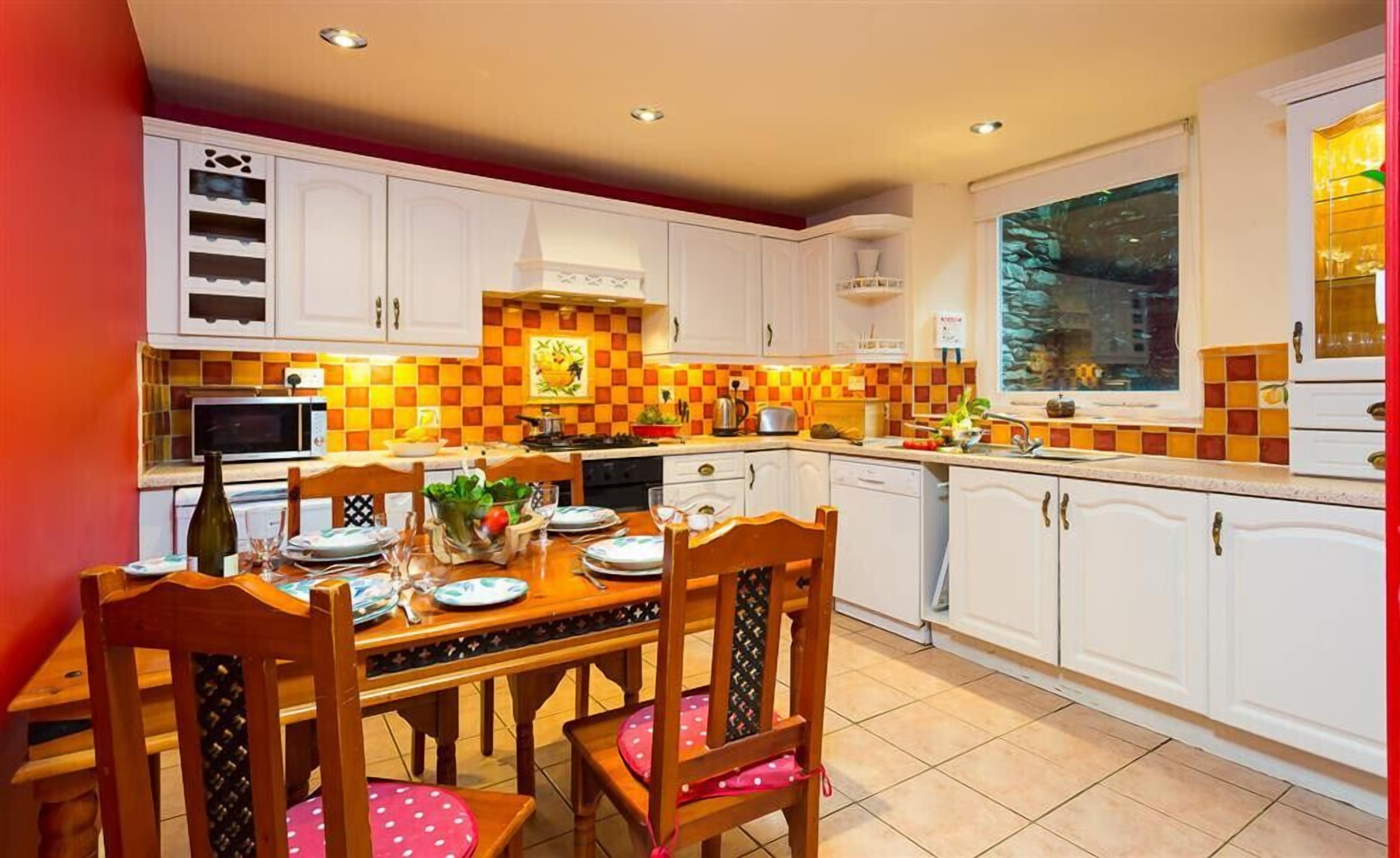 Um frigorífico, uma máquina de lavar louça, utensílios de cozinha 