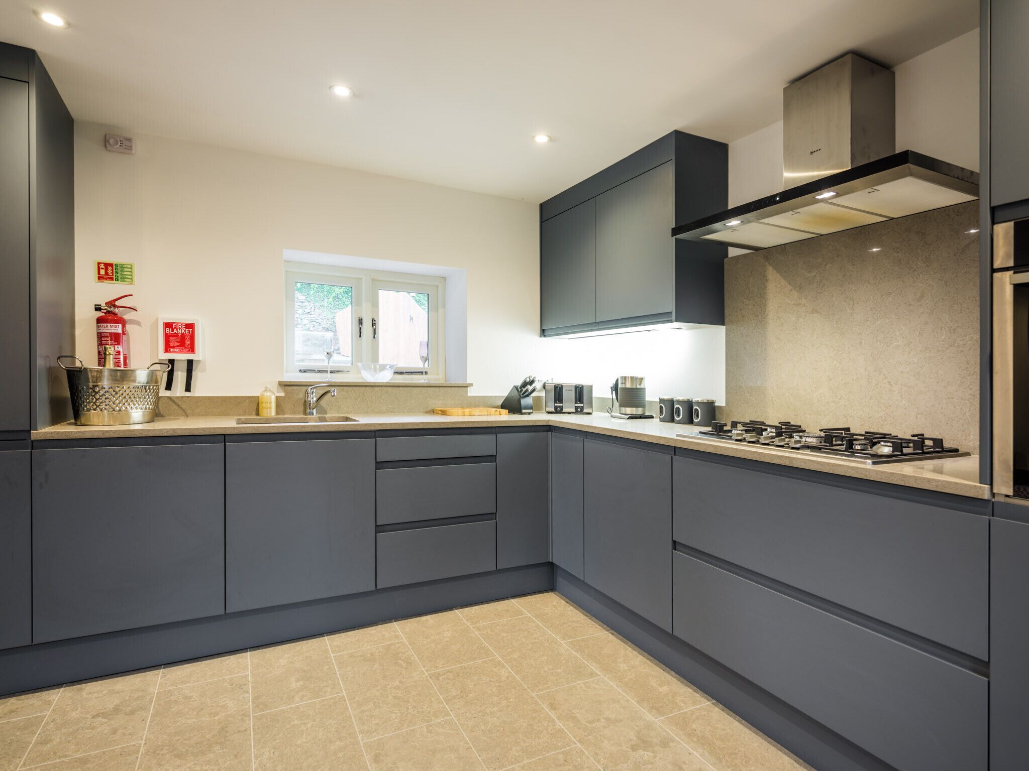 Um frigorífico, uma máquina de lavar louça, utensílios de cozinha 