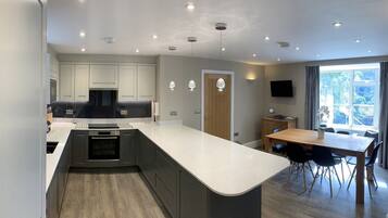 Um frigorífico, uma máquina de lavar louça, utensílios de cozinha