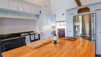 Um frigorífico, uma máquina de lavar louça, utensílios de cozinha