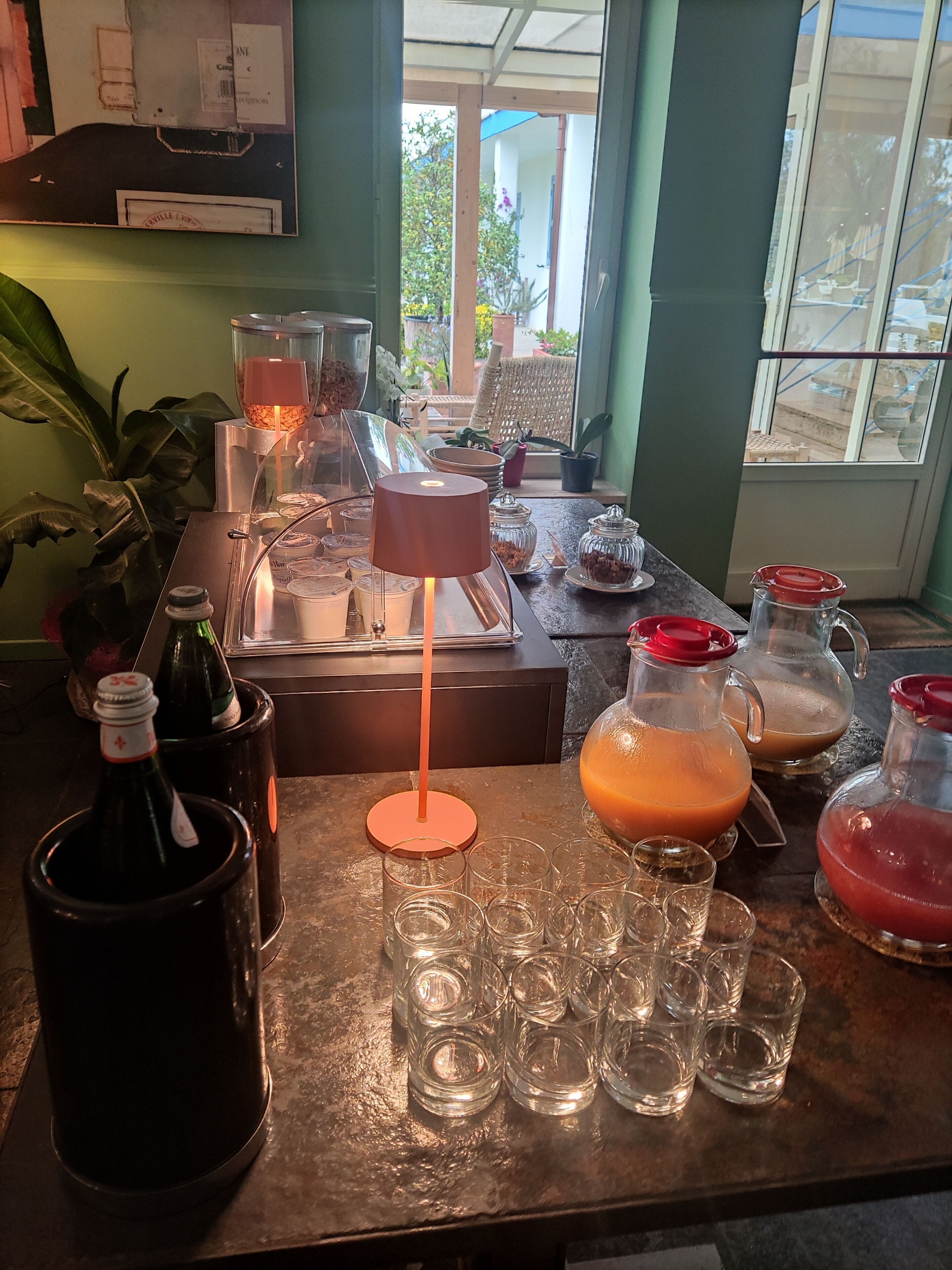 Uma área de bar com diversos dosadores de bebidas, copos e garrafas.