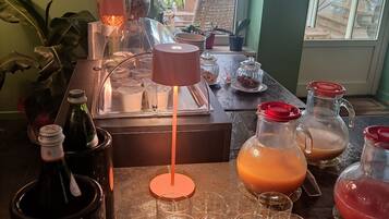Uma área de bar com diversos dosadores de bebidas, copos e garrafas.