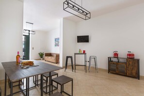 Uma cozinha moderna com uma mesa de madeira, banquetas e um armário embutido com eletrodomésticos.