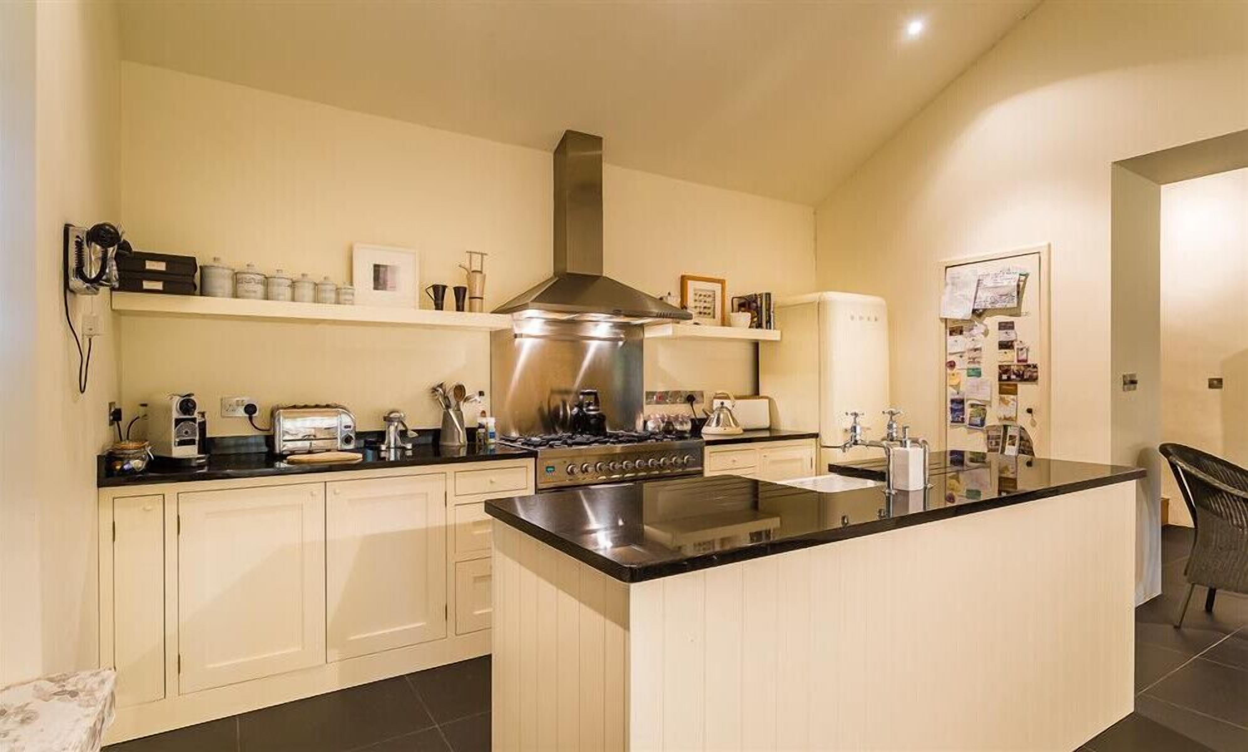 Um frigorífico, uma máquina de lavar louça, utensílios de cozinha 