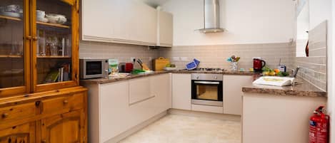 Um frigorífico, uma máquina de lavar louça, utensílios de cozinha