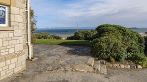 Um edifício de pedra com vista para o mar e montanhas.