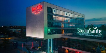 Um edifício de hotel moderno com um letreiro chamativo 'Hotel Sante' e a marca 'Studio Sante'.