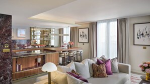 Quarto de hotel moderno com área de estar, cozinha e sala de jantar.