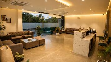 Uma sala de estar moderna com sofá, mesa de centro e balcão de recepção.
