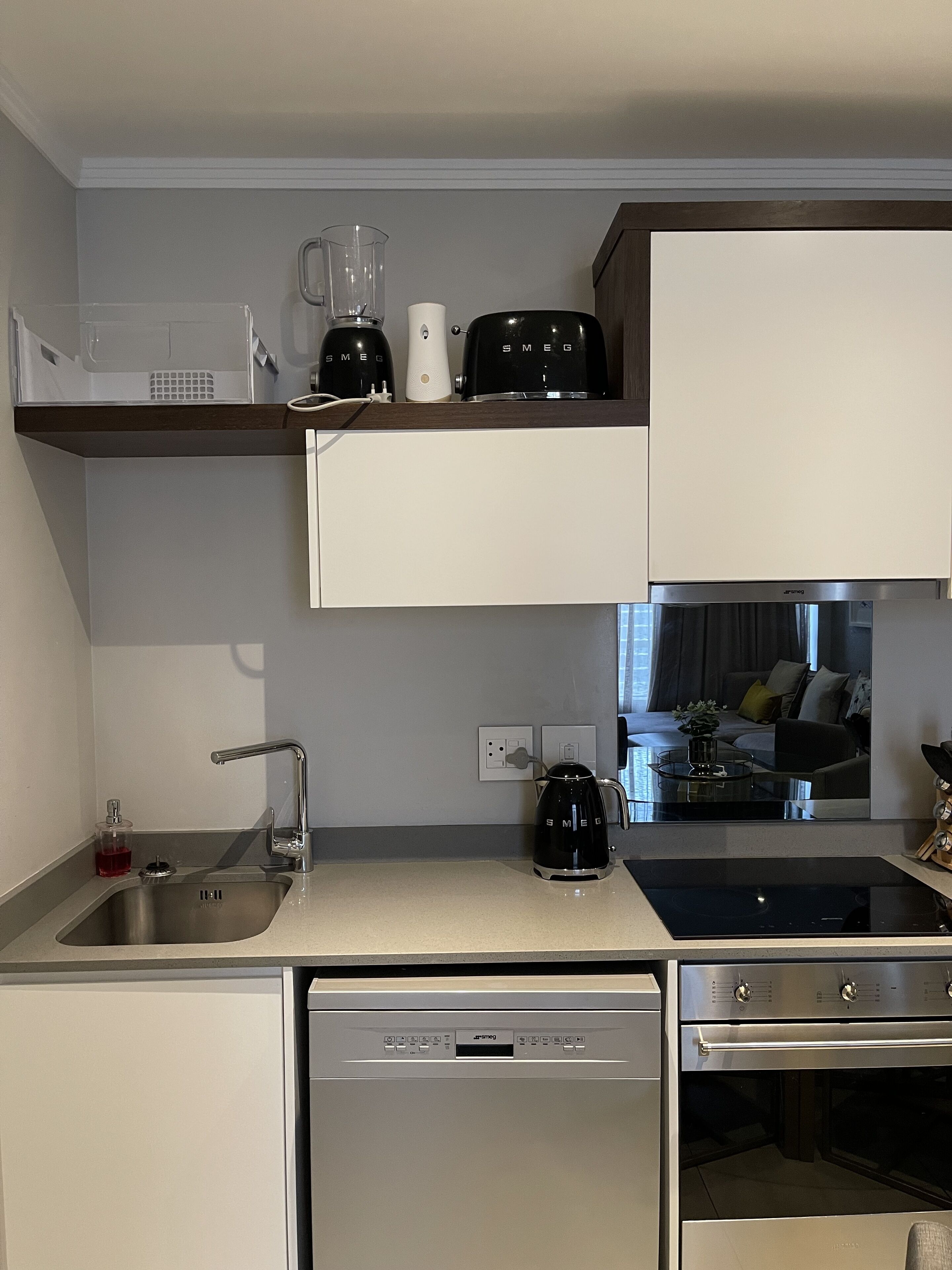 Cozinha moderna com lava-louças, fogão e máquina de café.