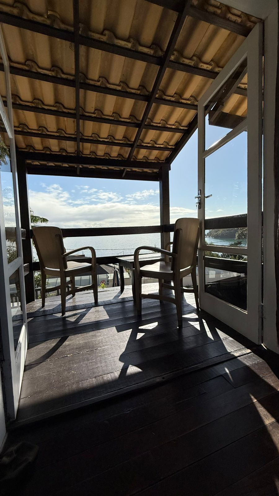 Pátio aberto com duas cadeiras e uma mesa, com vista panorâmica.