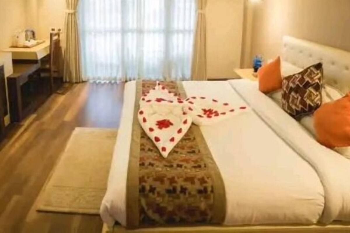 Quarto de hotel com uma cama, uma escrivaninha e uma cadeira.