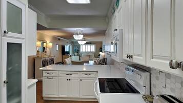 Apartamento em Condomínio Fechado, várias camas, varanda, vista para o oceano | Cozinha privada | Um frigorífico, um micro-ondas, um forno, uma placa de cozinha