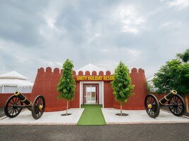Resort Unity Holiday, com fachada de tijolos, entrada verde e dois canhões de cada lado.
