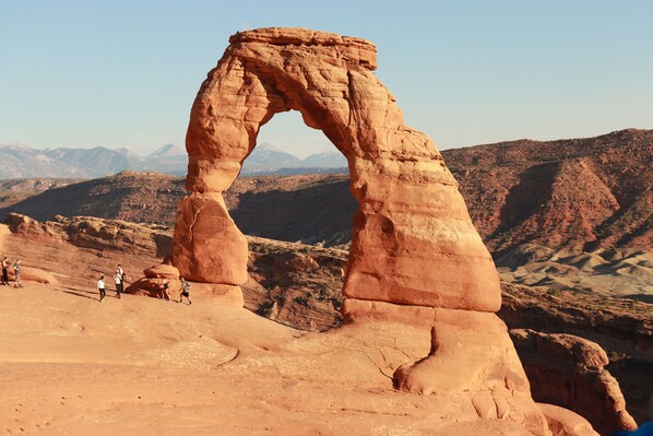 Formação rochosa natural em arco, com vista ampla da paisagem ao redor.