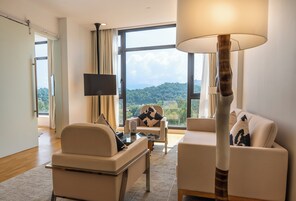 Quarto de hotel moderno com uma grande janela que oferece uma vista panorâmica, televisão de tela plana e mobiliário contemporâneo.