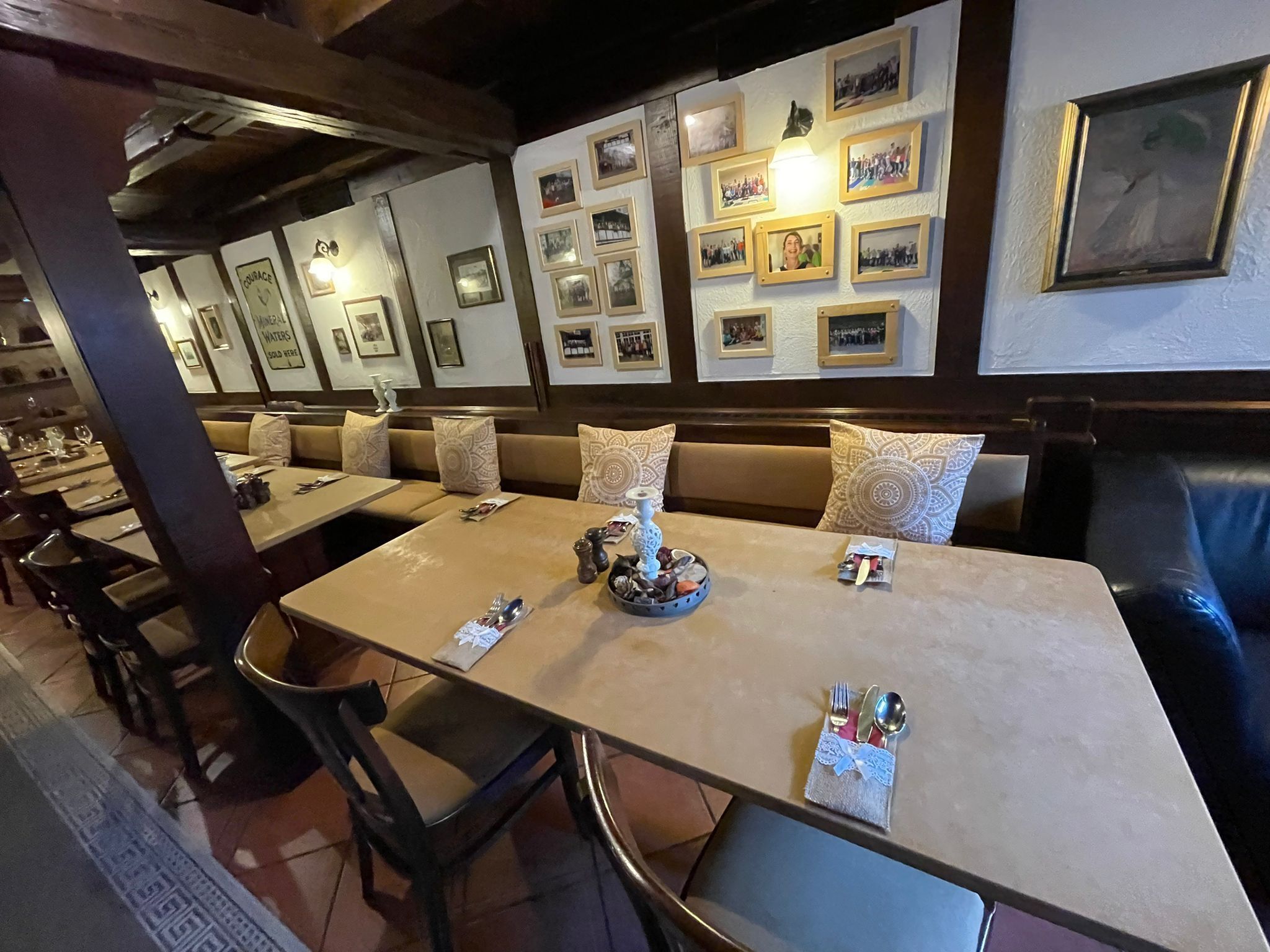 Um restaurante com cabines e mesas, cada conjunto com talheres e guardanapos.