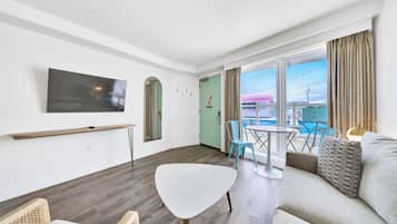 Suite, 1 cama queen-size e sofá-cama, vista para a piscina | Sala de estar | Televisor LED de 43 polegadas com canais por cabo