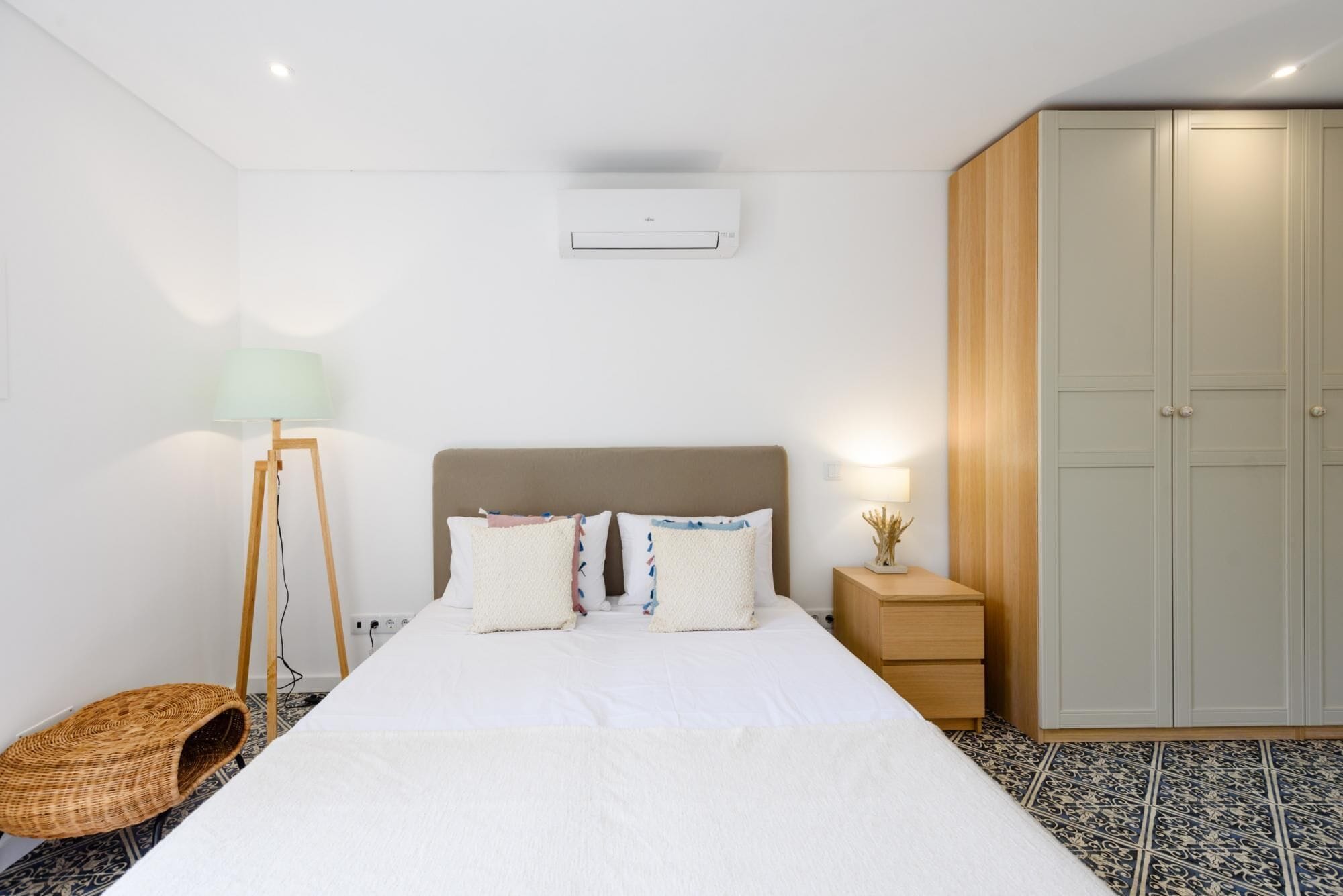 Quarto com cama, mesa de cabeceira, luminária, guarda-roupa e abajur.