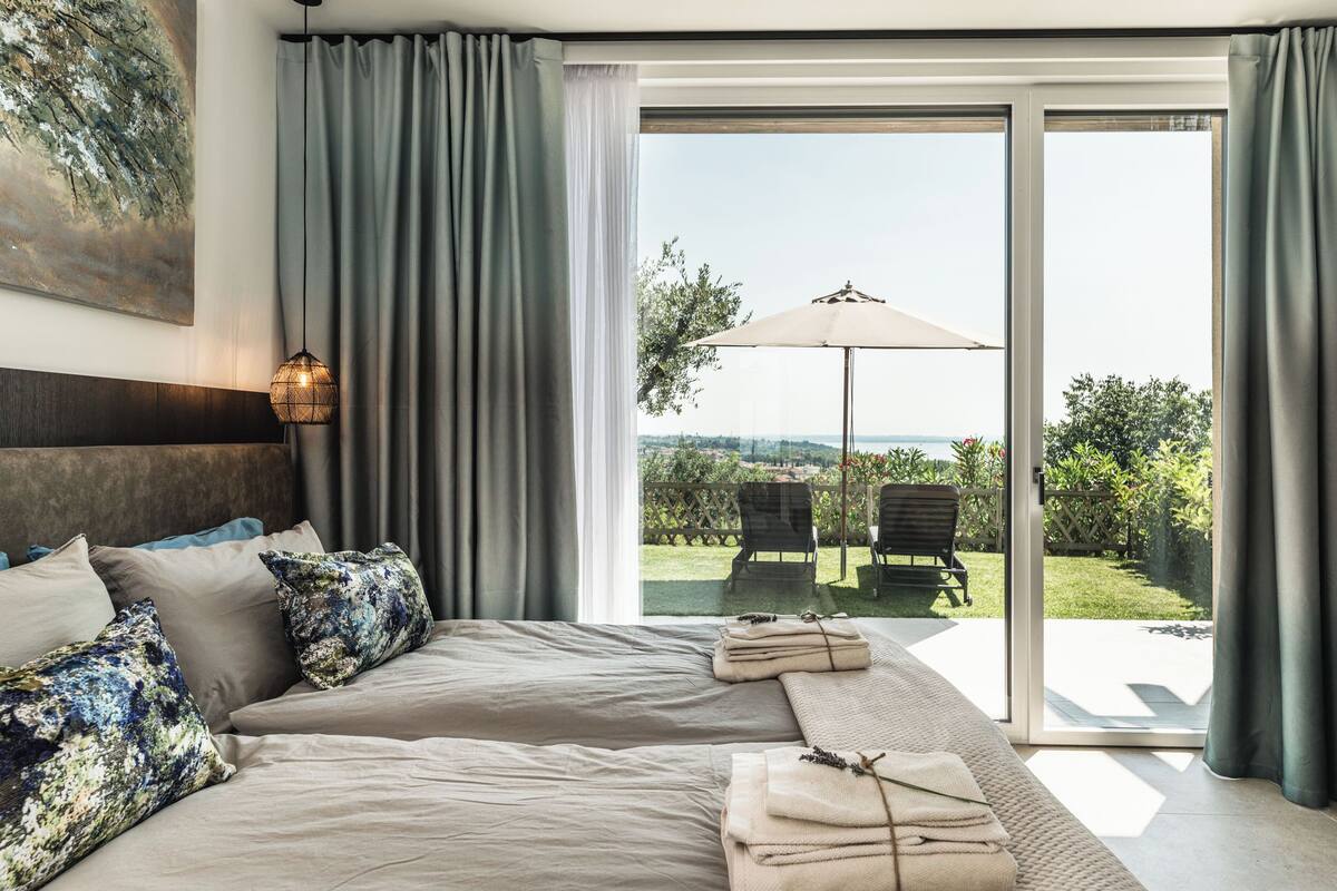 Quarto com duas camas, uma janela grande e vista para o exterior.