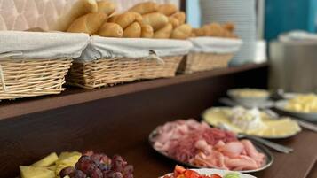 Buffet com diversos alimentos, incluindo frutas, legumes e carnes.
