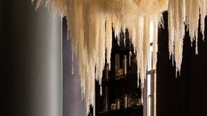 Uma área de bar com um balcão comprido, diversos frascos e objetos decorativos.