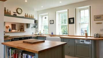 Um frigorífico, uma máquina de lavar louça, utensílios de cozinha