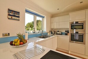 Um frigorífico, uma máquina de lavar louça, utensílios de cozinha 