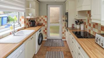 Um frigorífico, uma máquina de lavar louça, utensílios de cozinha