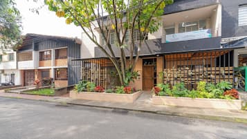 Um edifício de dois andares com varanda, entrada fechada por portão e placa indicando 'Contadores Públicos'.
