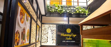 Interior de hotel com um letreiro para 'Hummida Cave Suites' e um aquário.