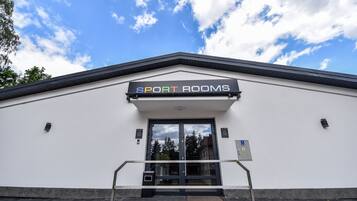 Um edifício com uma placa que diz "SPORT ROOMS" e um conjunto de degraus que levam à entrada.