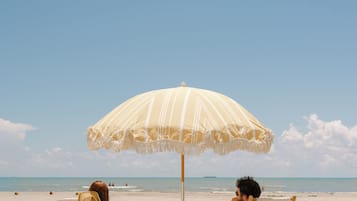 Uma praia privada, espreguiçadeiras, guarda-sóis de praia