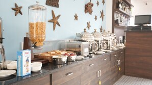 Disposição de buffet com diversos alimentos e utensílios de servir.