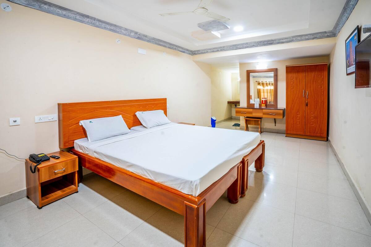 Quarto bem arrumado com cama de madeira, mesa de cabeceira e guarda-roupa.