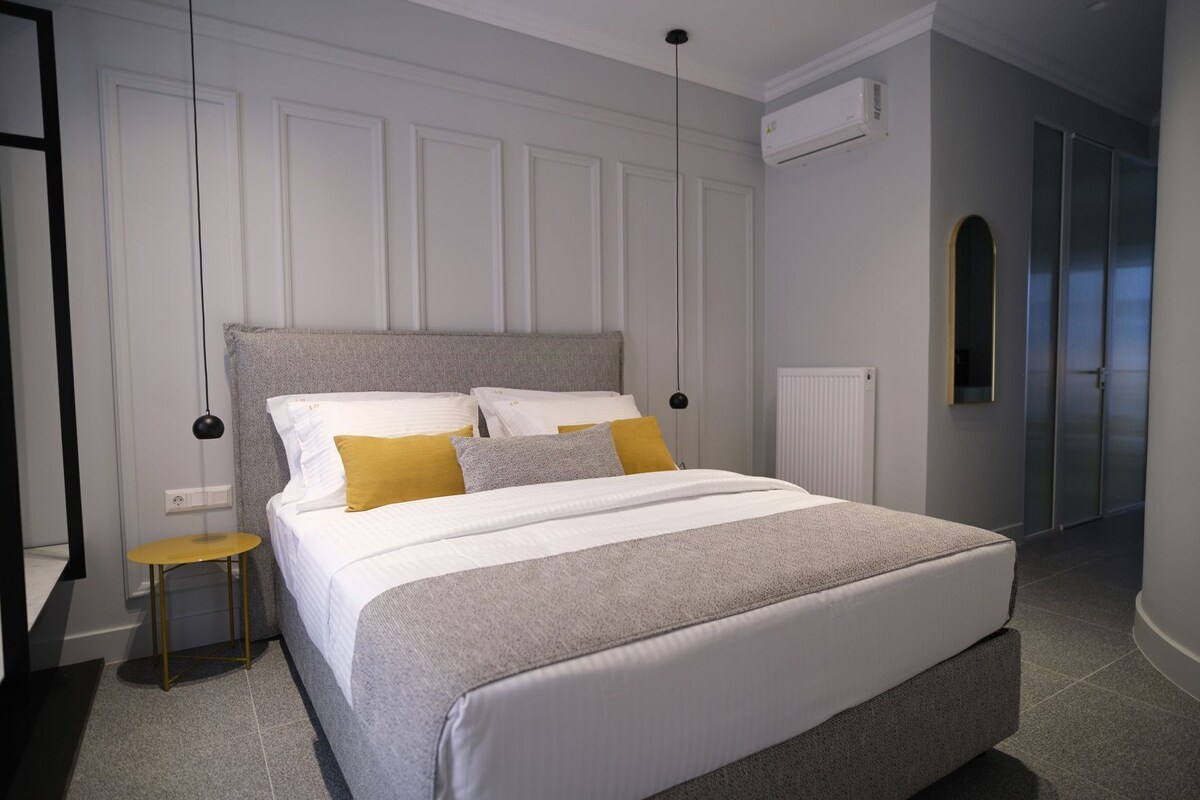 Quarto com cama, mesa de cabeceira e radiador.
