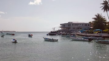 Marina com vários barcos atracados, um edifício com varanda e céu claro.